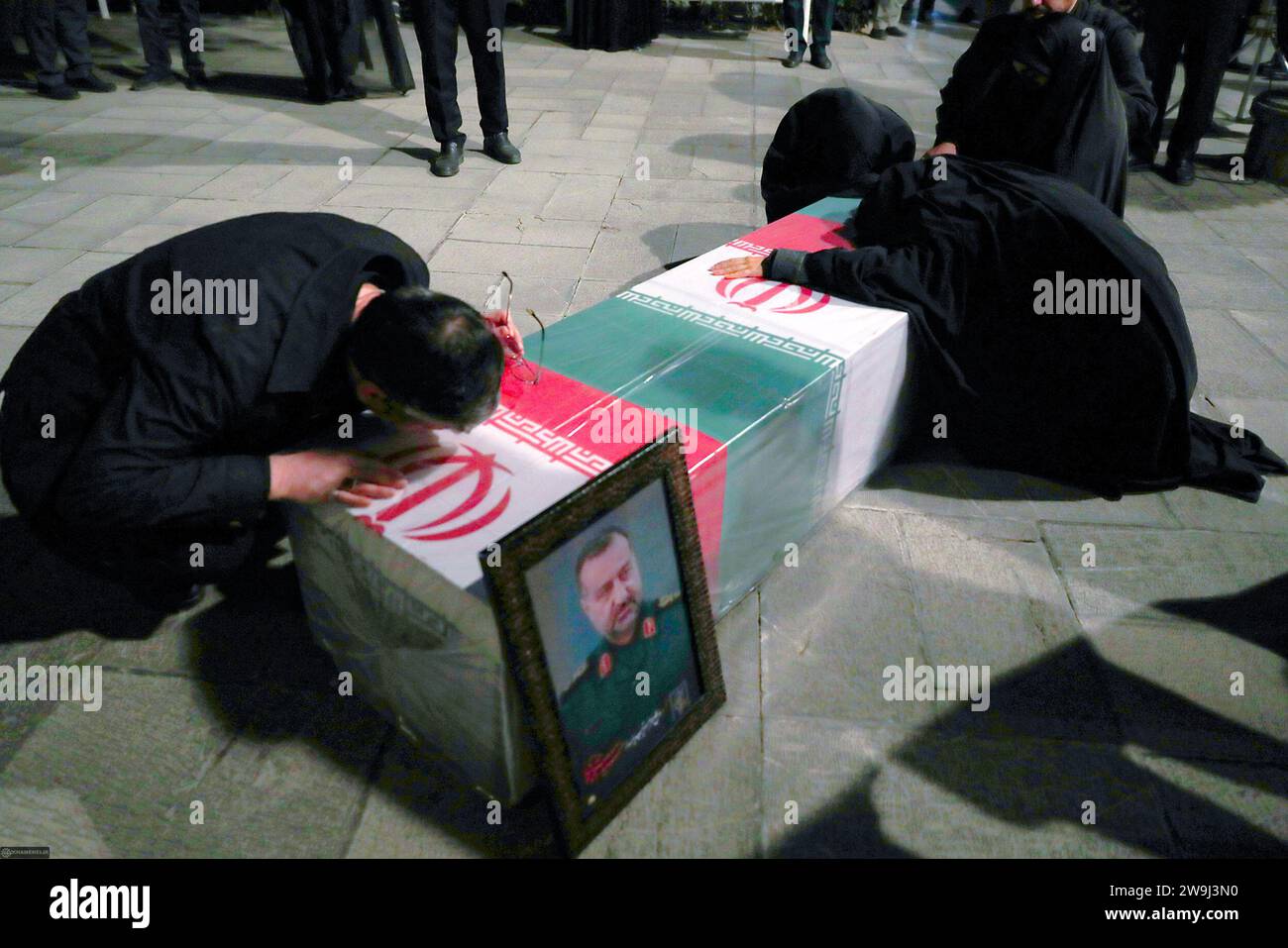 Tehran, Iran. 28th Dec, 2023. Relatives mourning over the coffin of ...