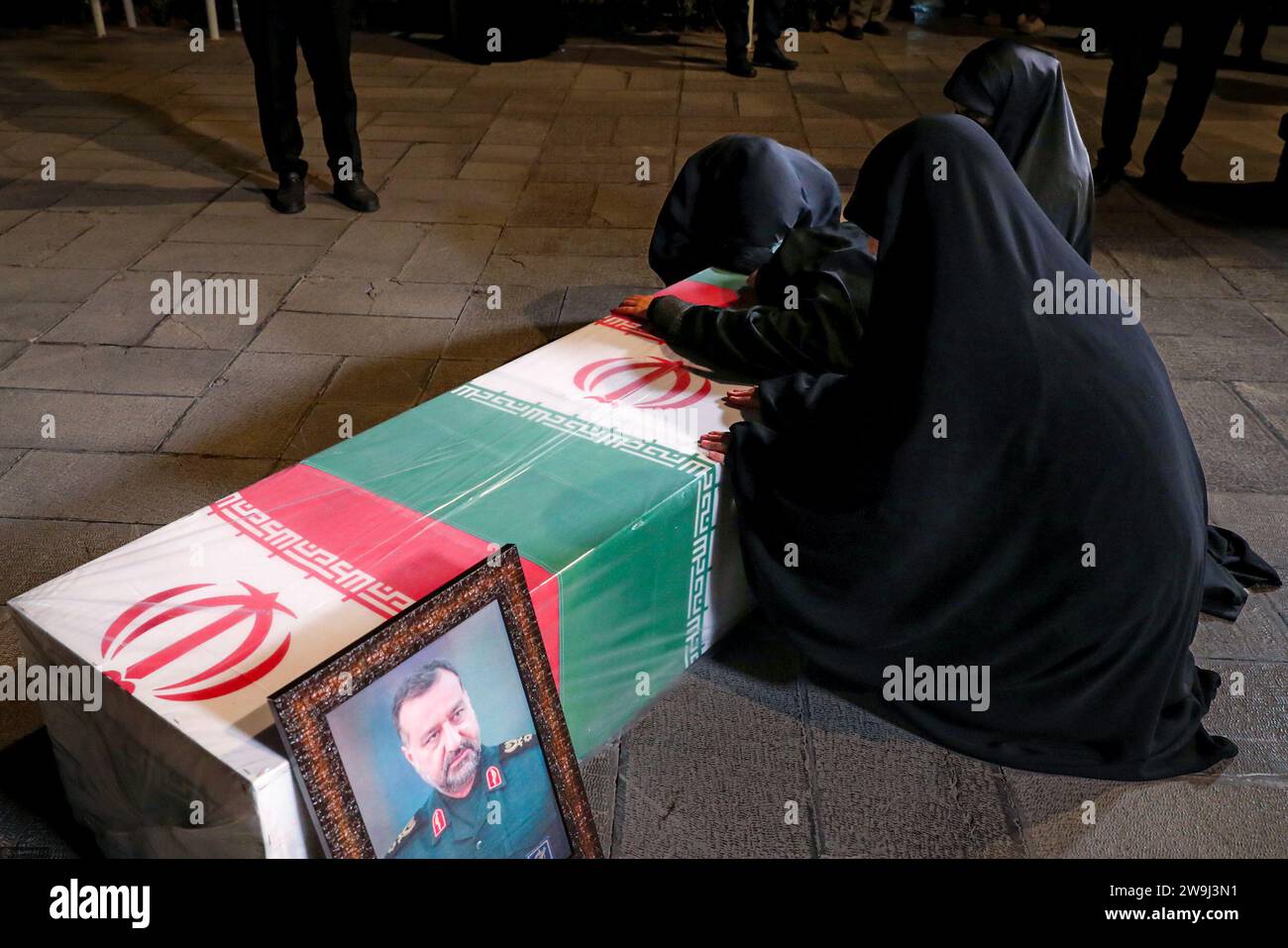 Tehran, Iran. 28th Dec, 2023. Relatives mourning over the coffin of ...