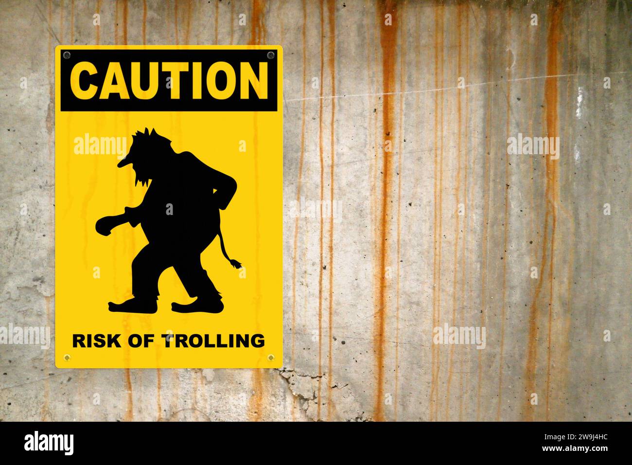 Yellow warning sign screwed to a concrete wall to warn about a threat ...