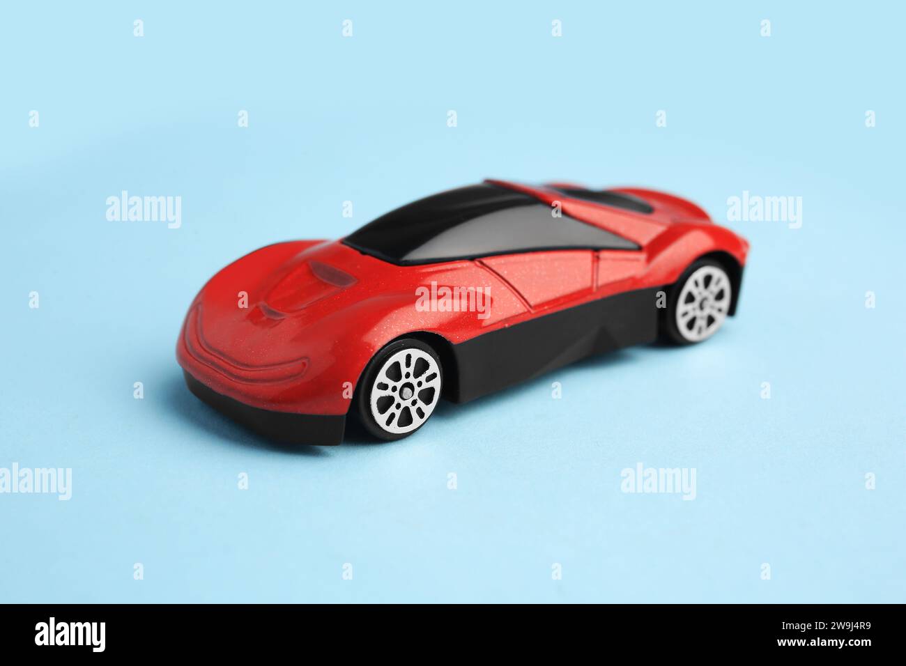 One red car on light blue background. Children`s toy Stock Photo - Alamy