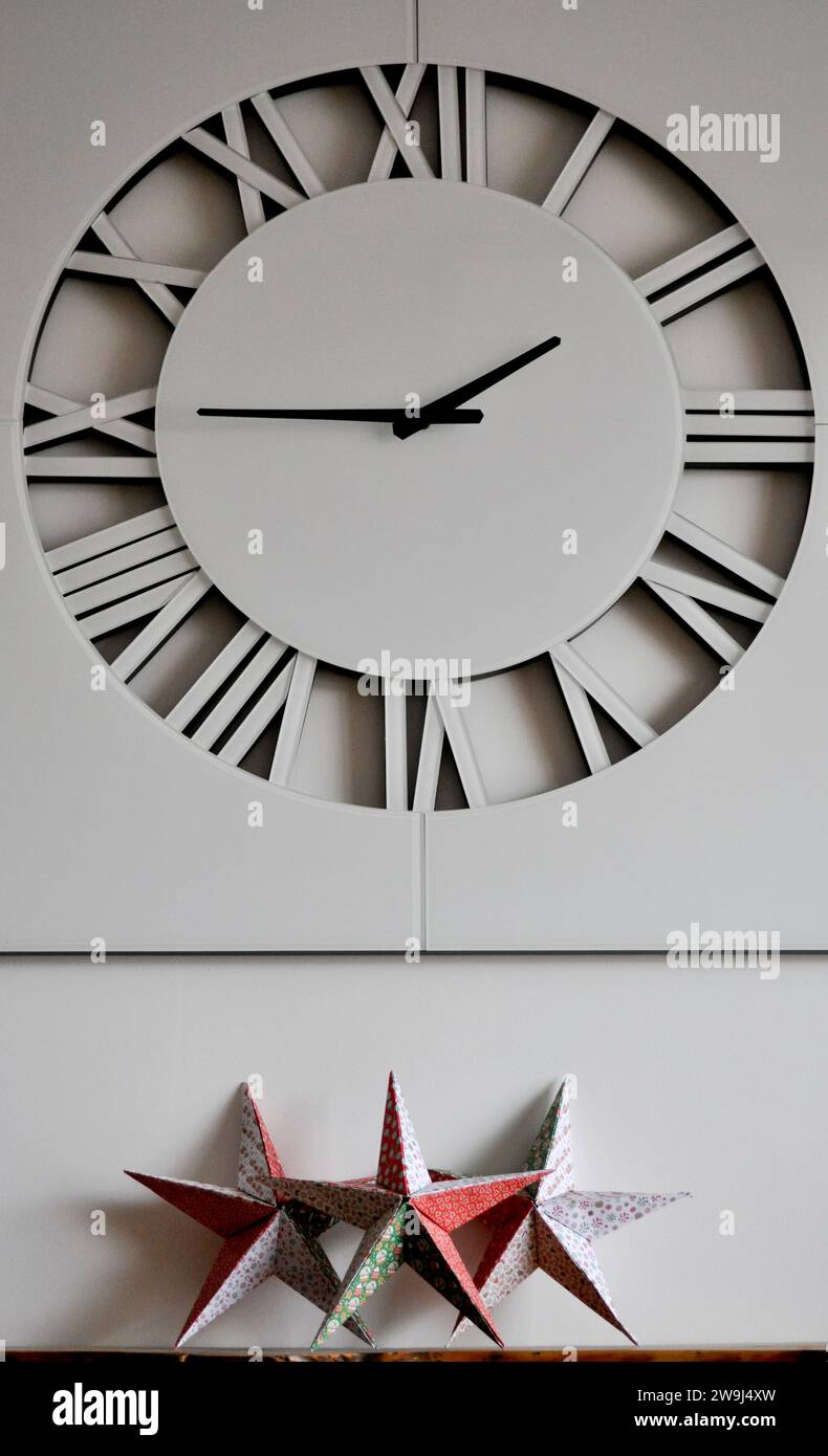 A trio of handmade origami stars on a wooden mantlepiece, under a white ...