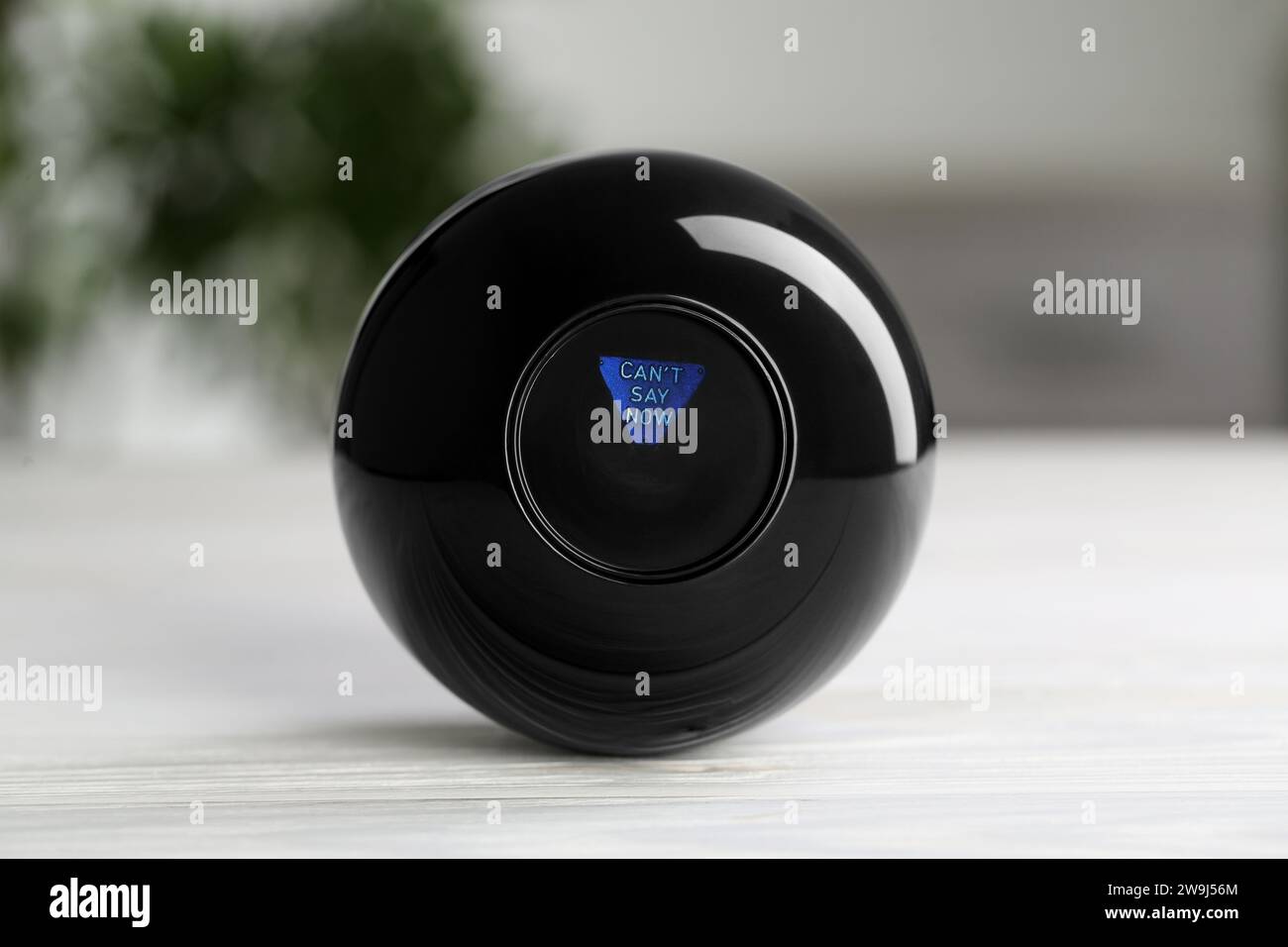 Magic eight ball with prediction Can't Say Now on light table, closeup ...
