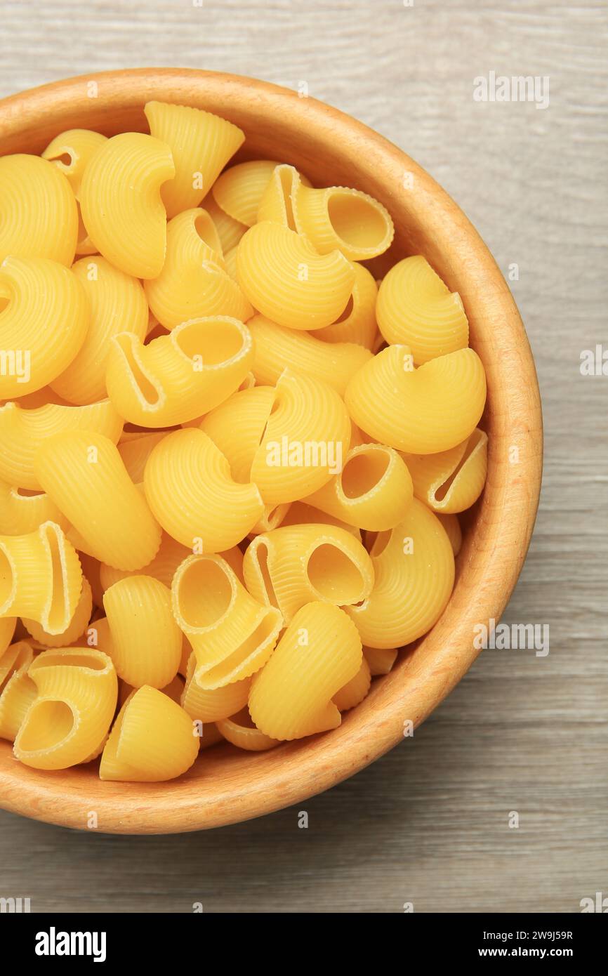 Raw macaroni pasta in bowl on light grey wooden table, top view Stock ...