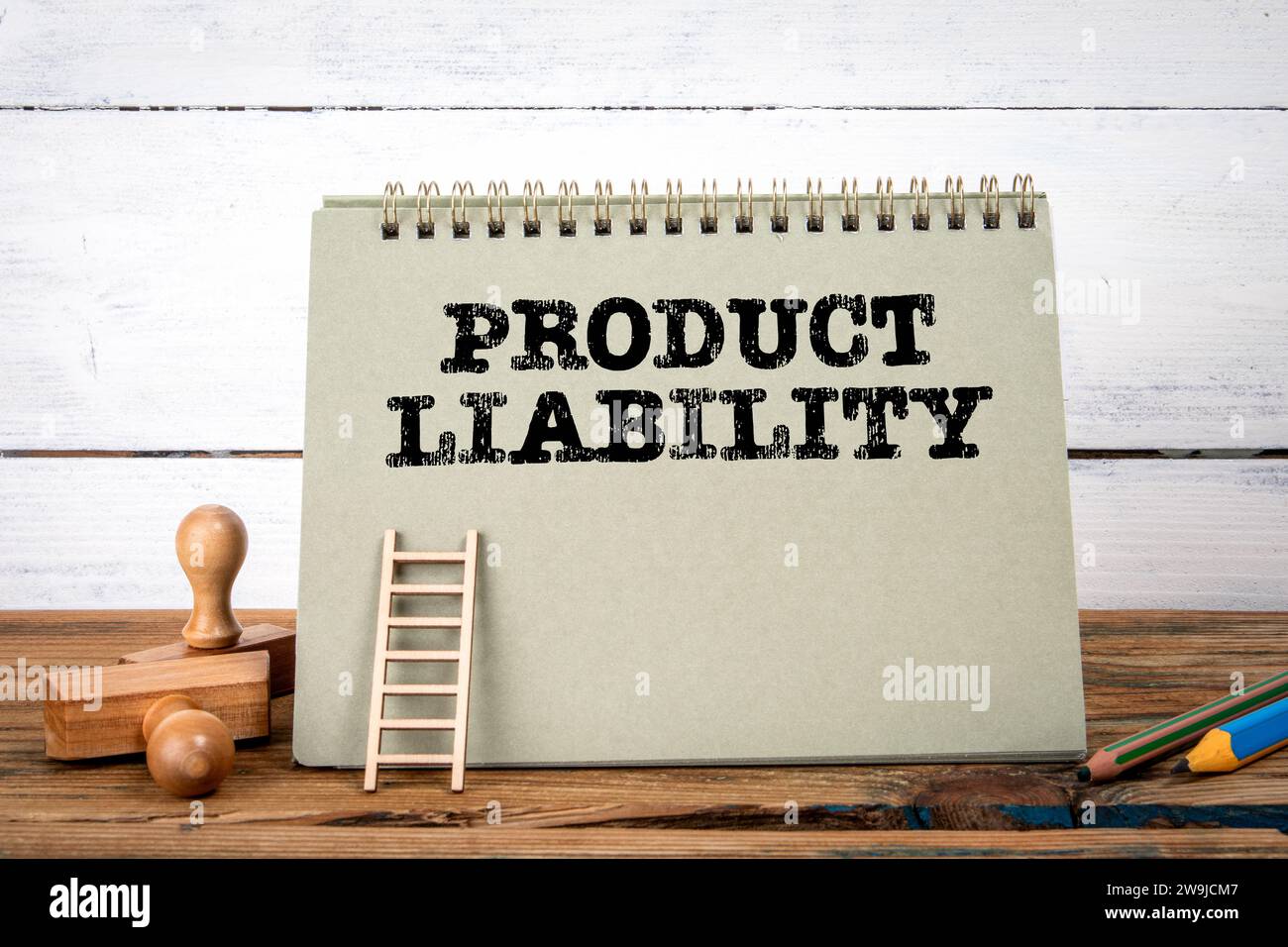 PRODUCT LIABILITY. Green notepad on wooden texture table and white ...