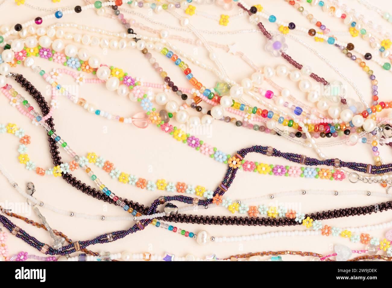 Colorful chains of beads, pearls and natural stones scattered on a ...