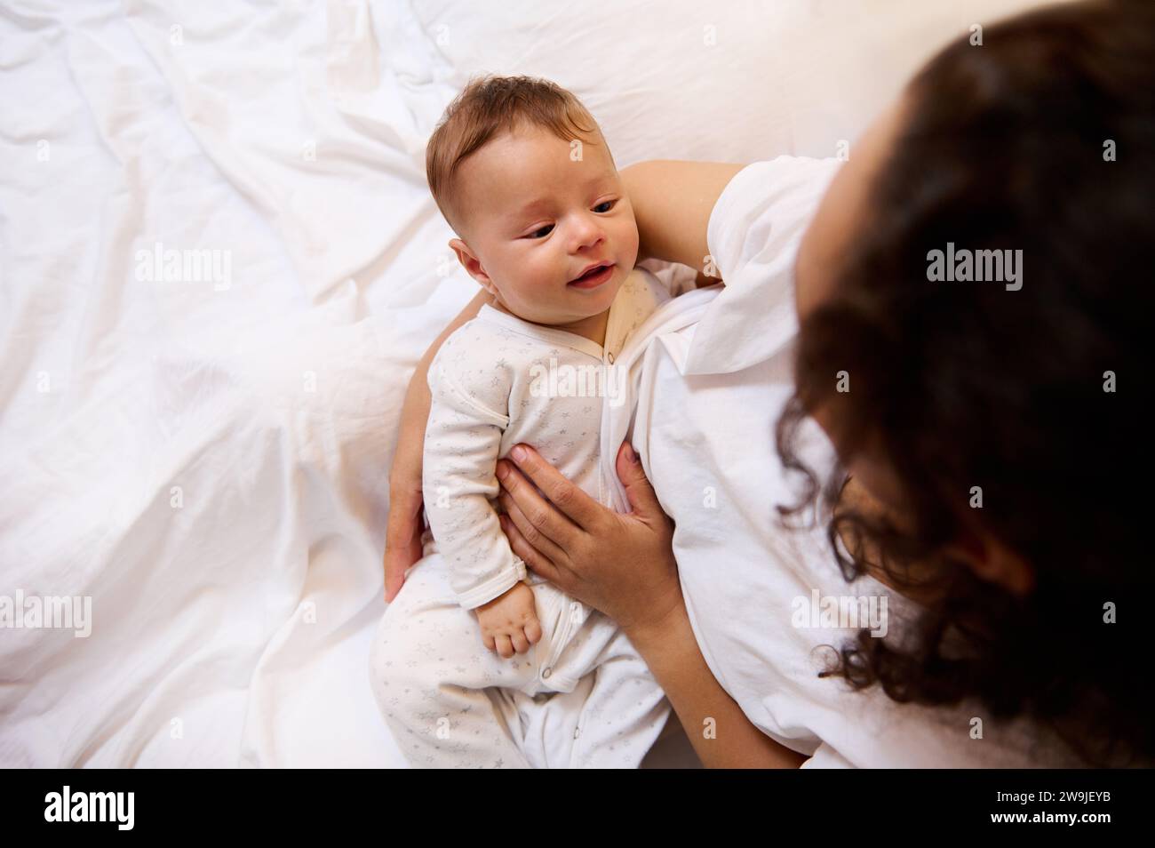 View from above of Caucasian child, adorable newborn baby in the hands ...