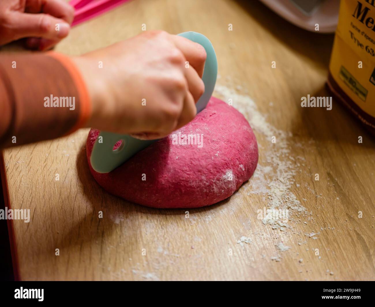 Hand dividing the dough for beetroot burger buns Stock Photo - Alamy