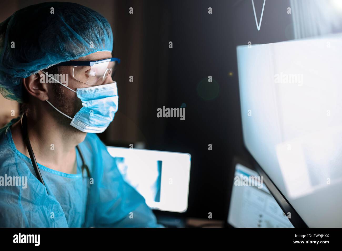 Surgeon examines fluorography images on a monitor in an operating room ...