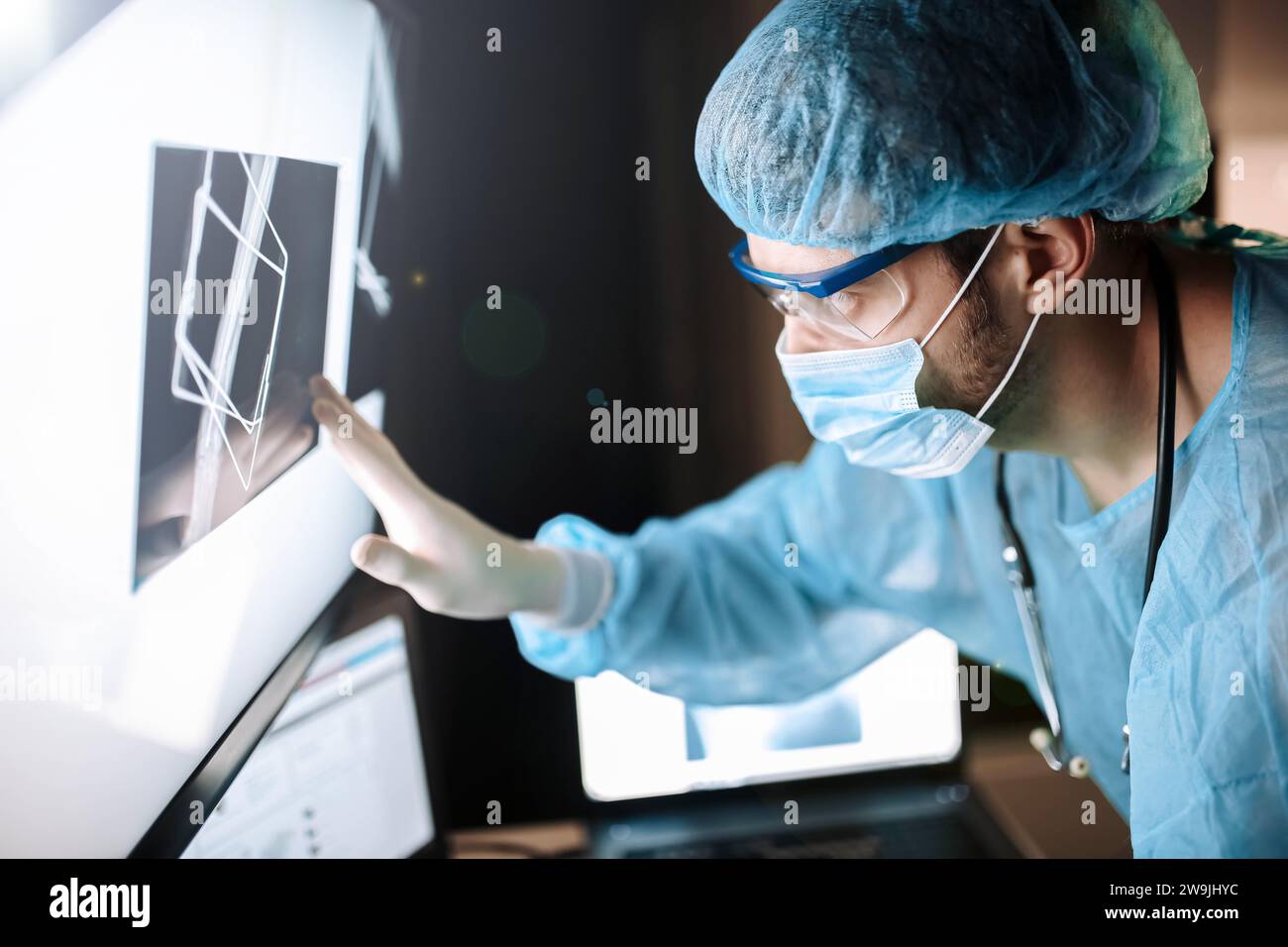 Surgeon examines fluorography images on a monitor in an operating room ...