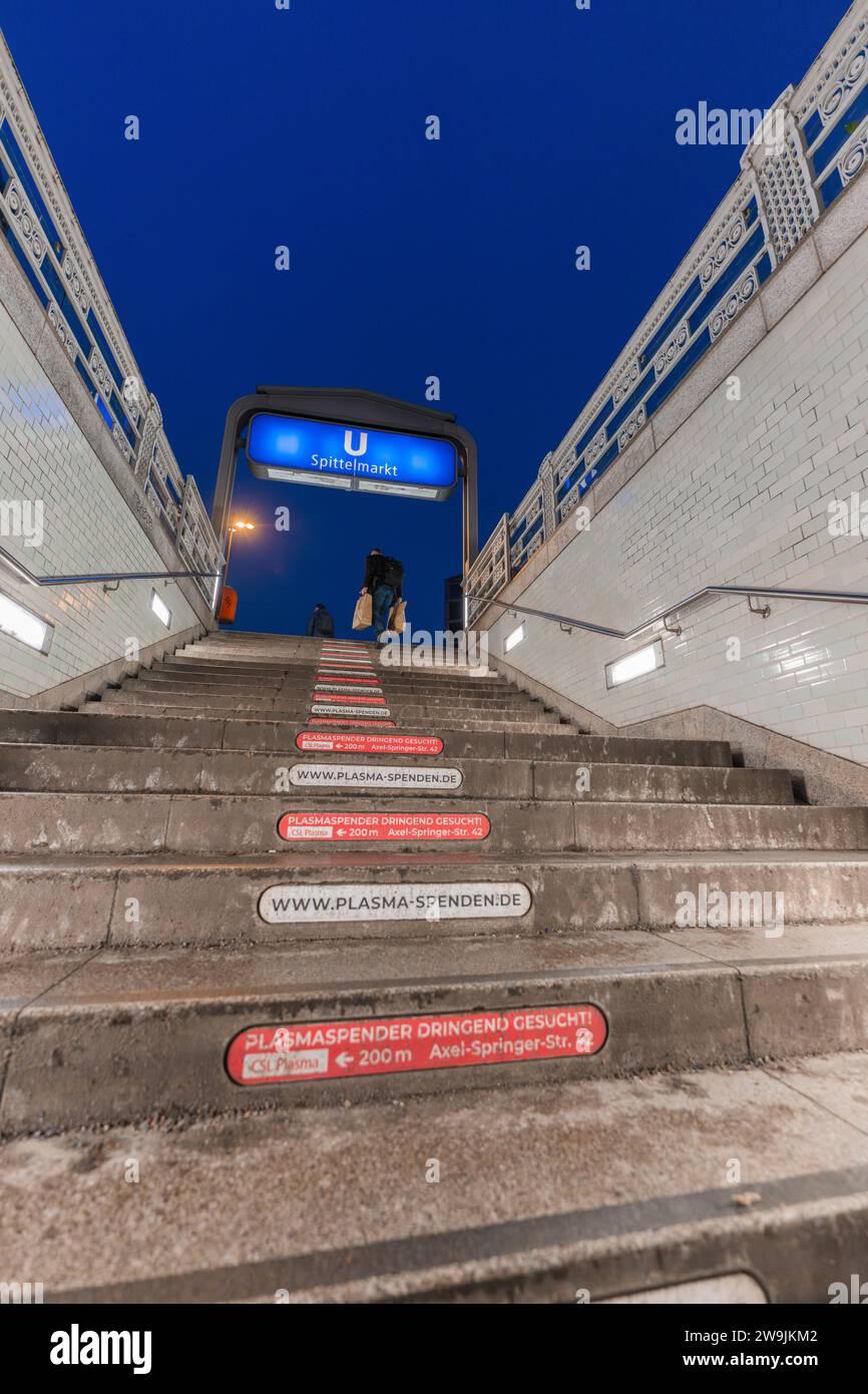 Underground entrance at night with steps and people passing by ...