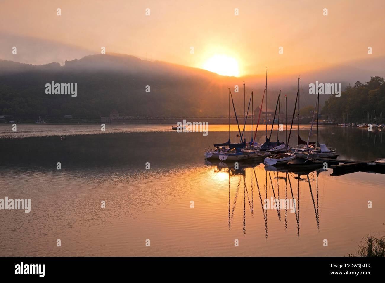 Sunrise over the Eder dam with dam wall and pleasure boats on the ...