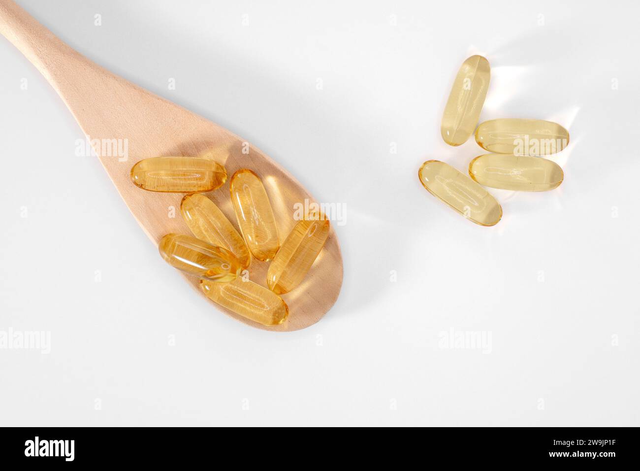 Omega 3 fish oil gel capsules on a neutral white background. Cod liver ...