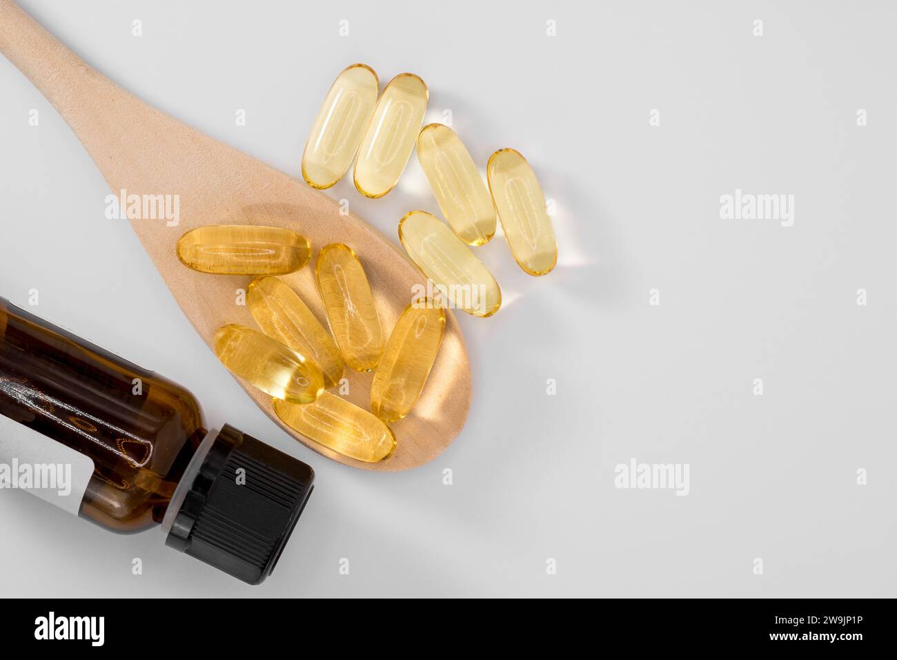 Omega 3 fish oil gel capsules on neutral white background and glass ...