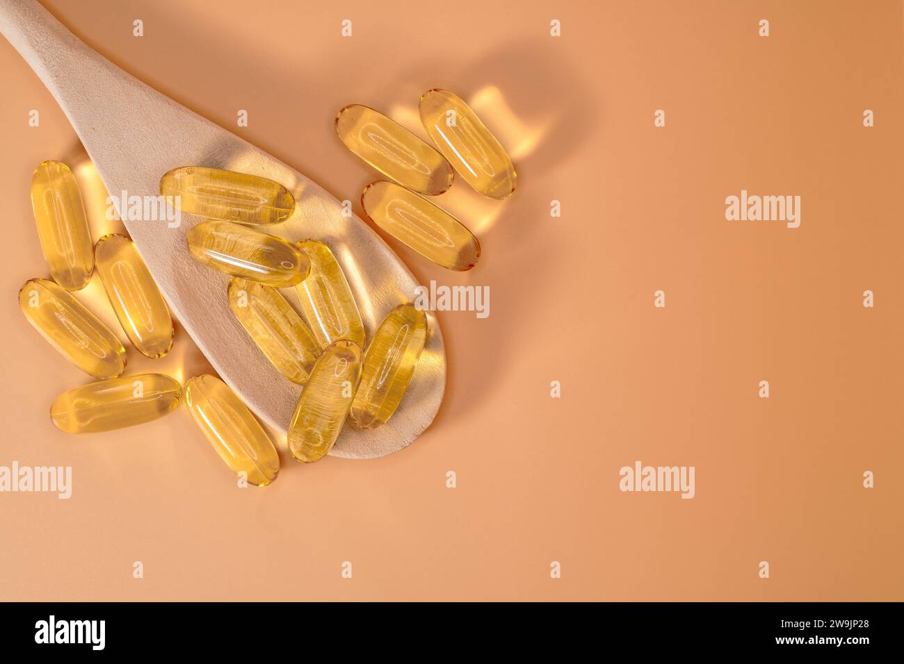 Omega 3 fish oil gel capsules on a neutral peach background. Cod liver ...