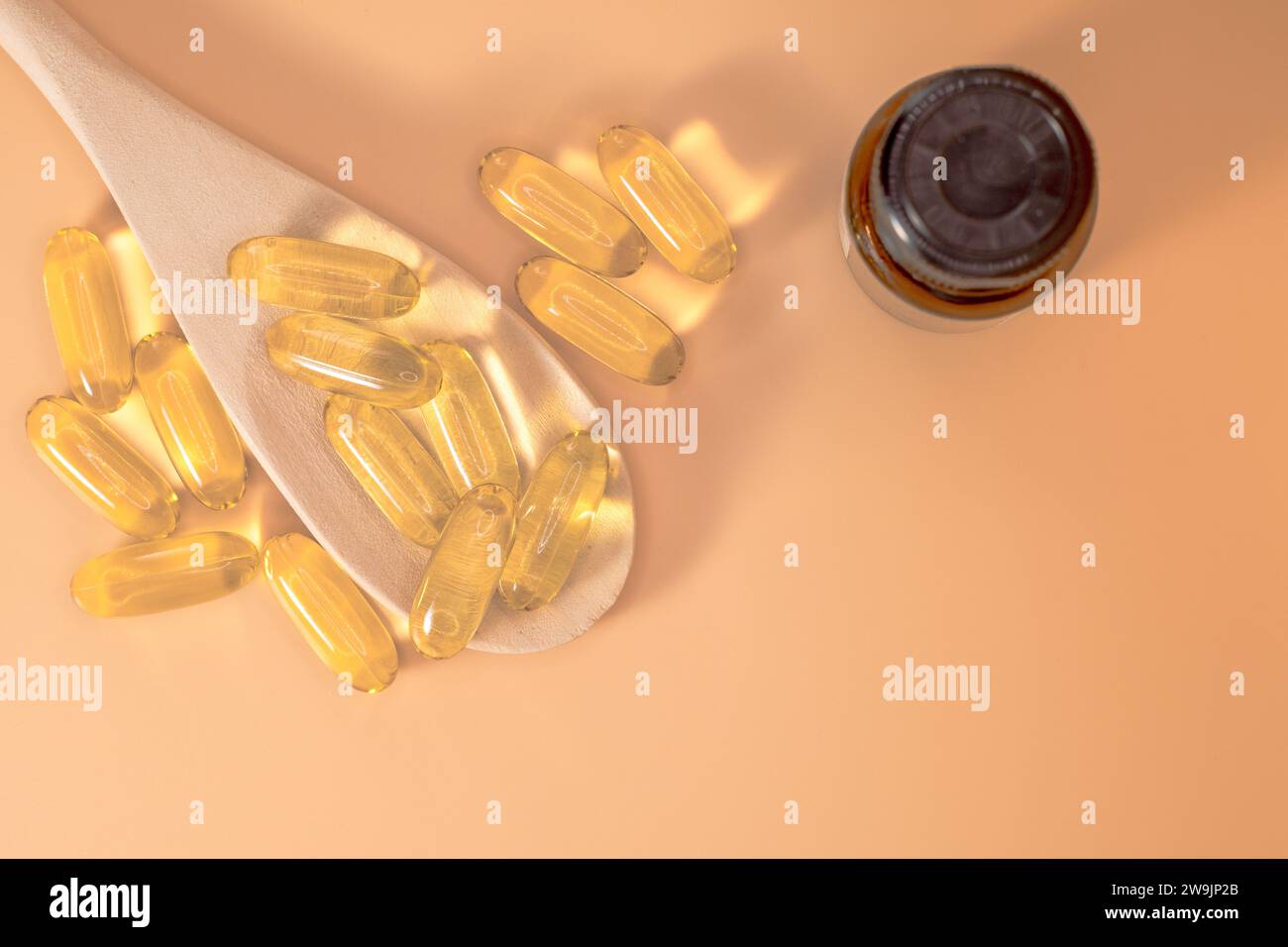 Omega 3 fish oil gel capsules on a neutral peach background. Cod liver ...