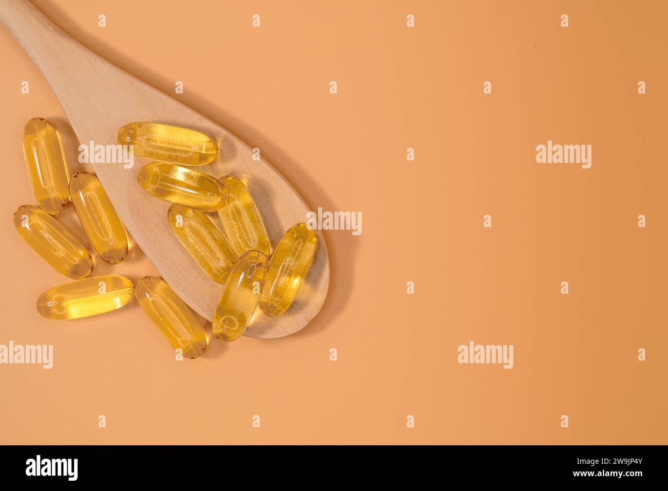 Omega 3 fish oil gel capsules on a neutral peach background. Cod liver ...