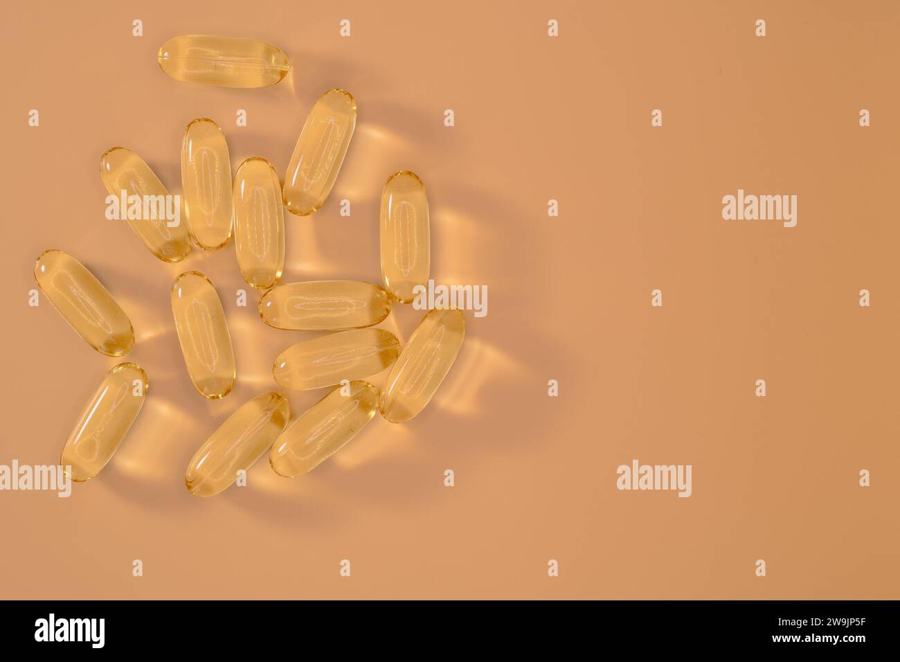 Omega 3 fish oil gel capsules on a neutral peach background. Cod liver ...