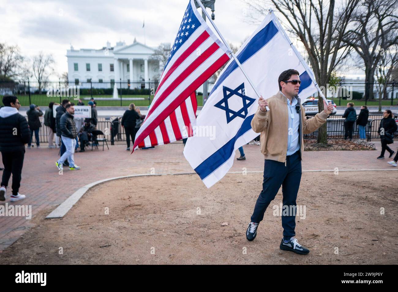 A man displays the US and Israeli flags in front of the White House in ...