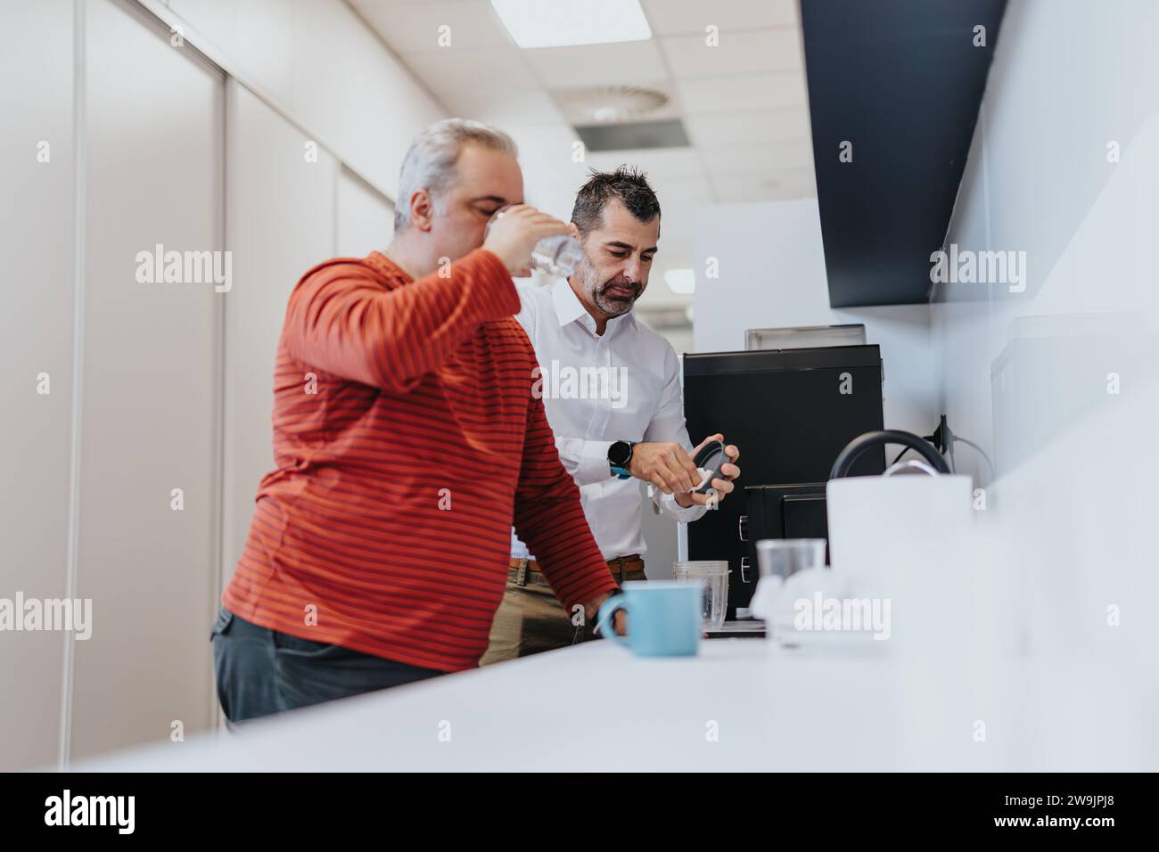 Male employee drinking water, refreshing himself after hard day at work Stock Photo - Alamy