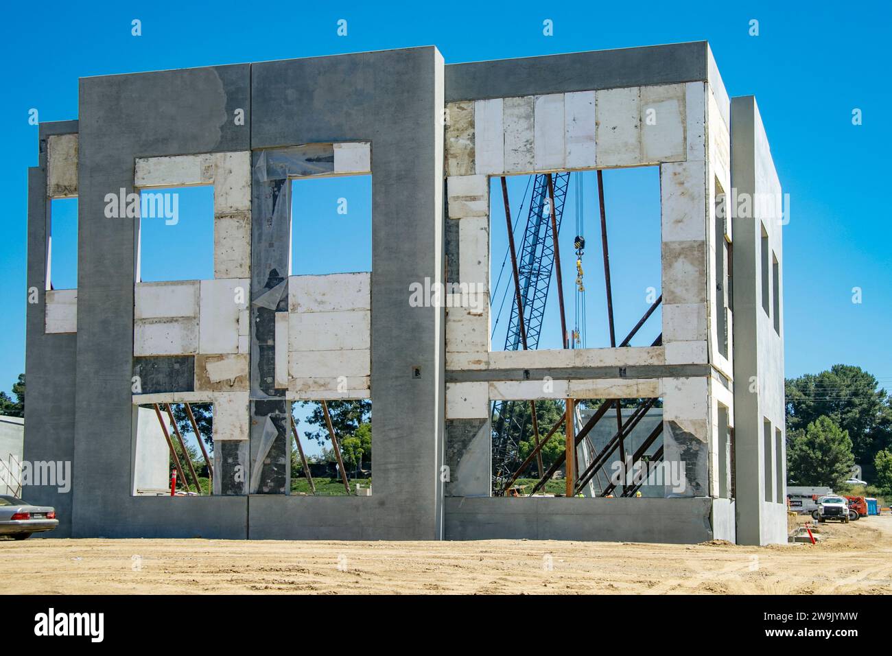 Prefabricated concrete walls of an office building are erected at the ...