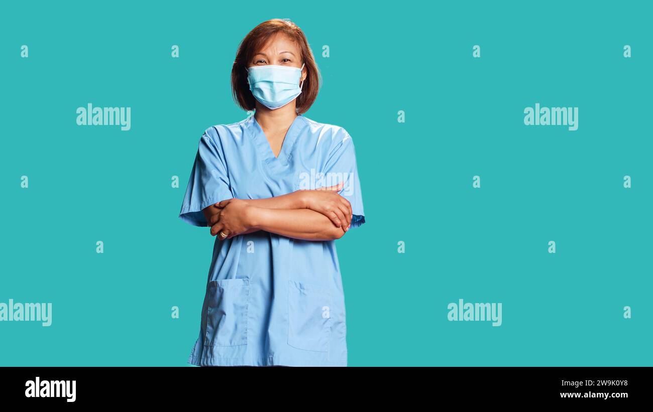 Upbeat smiling woman wearing protective clinical face mask to stop ...