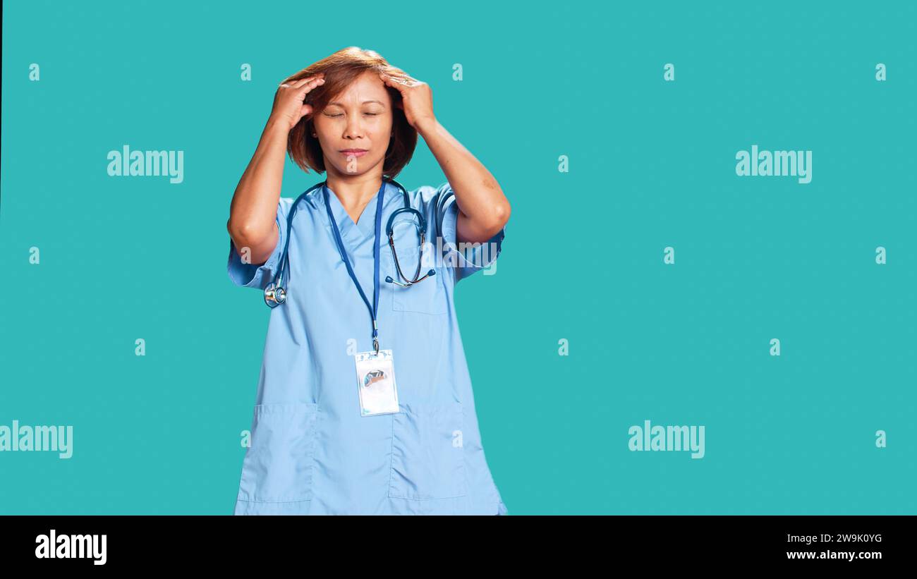 Overworked nurse suffering from migraine pain after exhausting day at ...