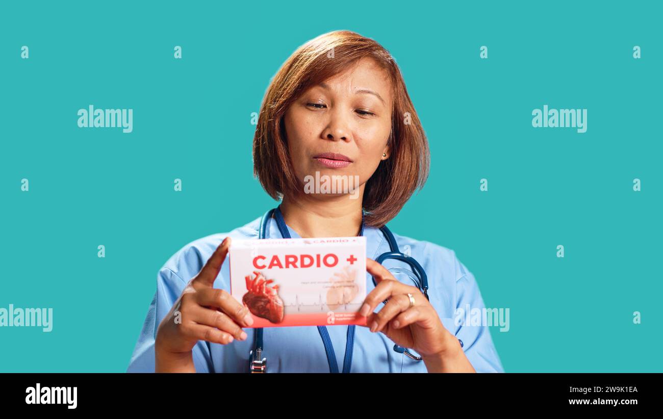 Healthcare professional holding miocardic tablets box, reading ...