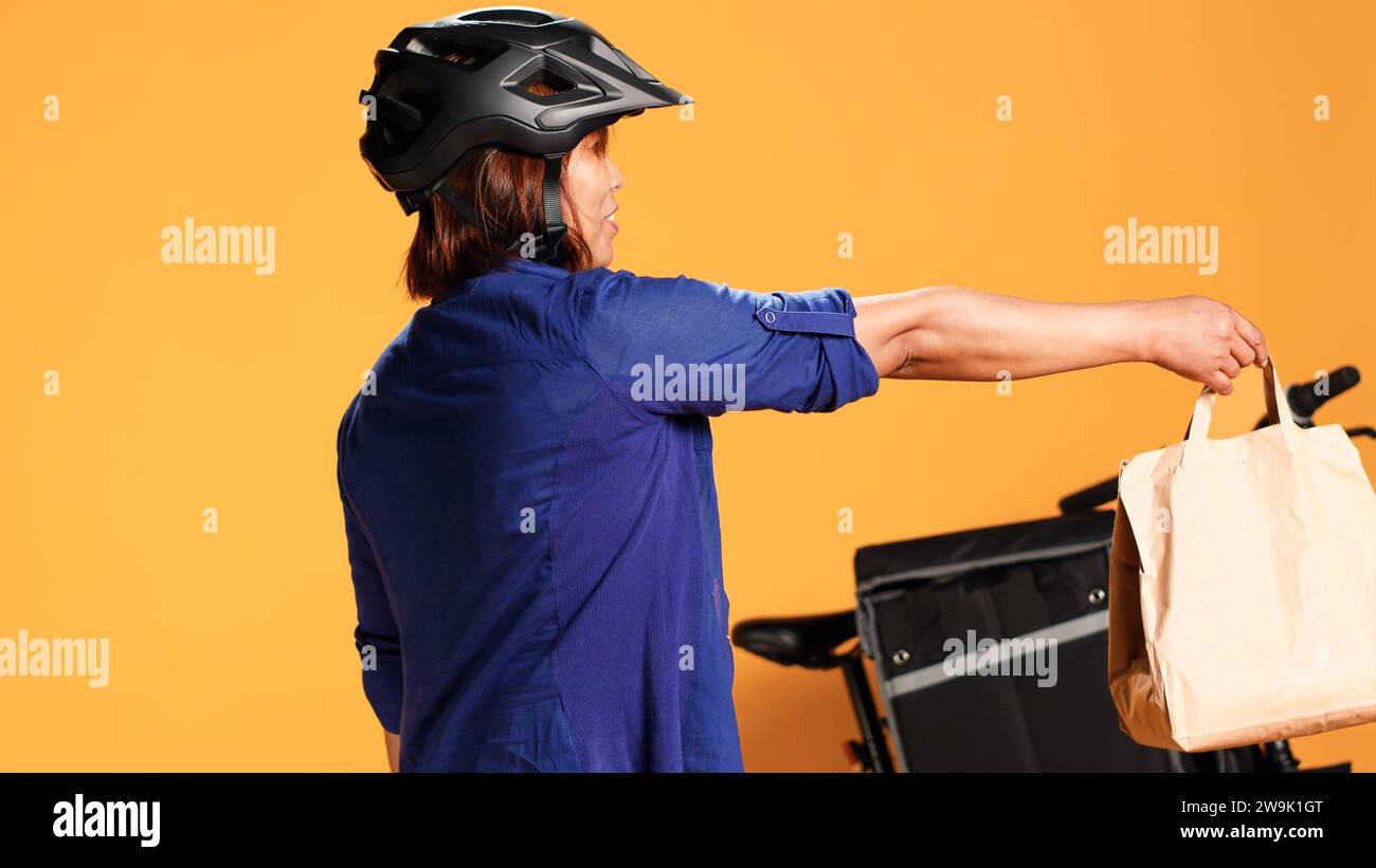 Close up of delivery bike rider greeting customer, offering takeout ...