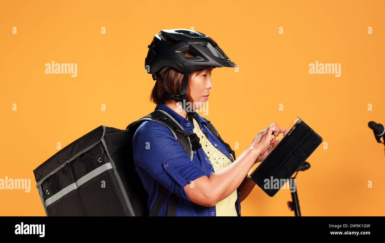 Part time delivery worker typing customer order details on tablet ...