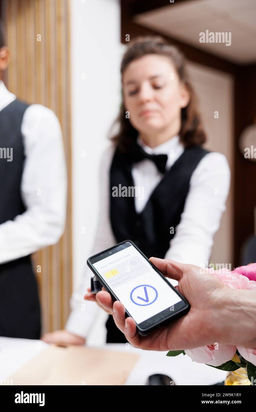 Female receptionist at front desk providing assistance to tourist using ...