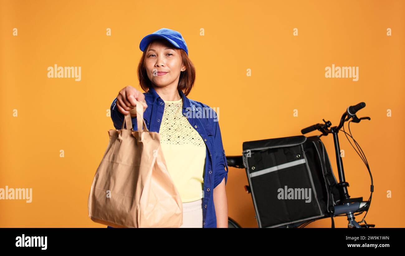 Slow motion portrait shot of friendly courier handing lunch bag to ...