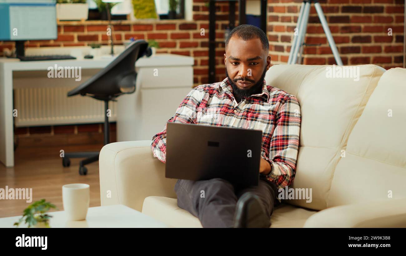 Easy going african american employee working from home on laptop ...