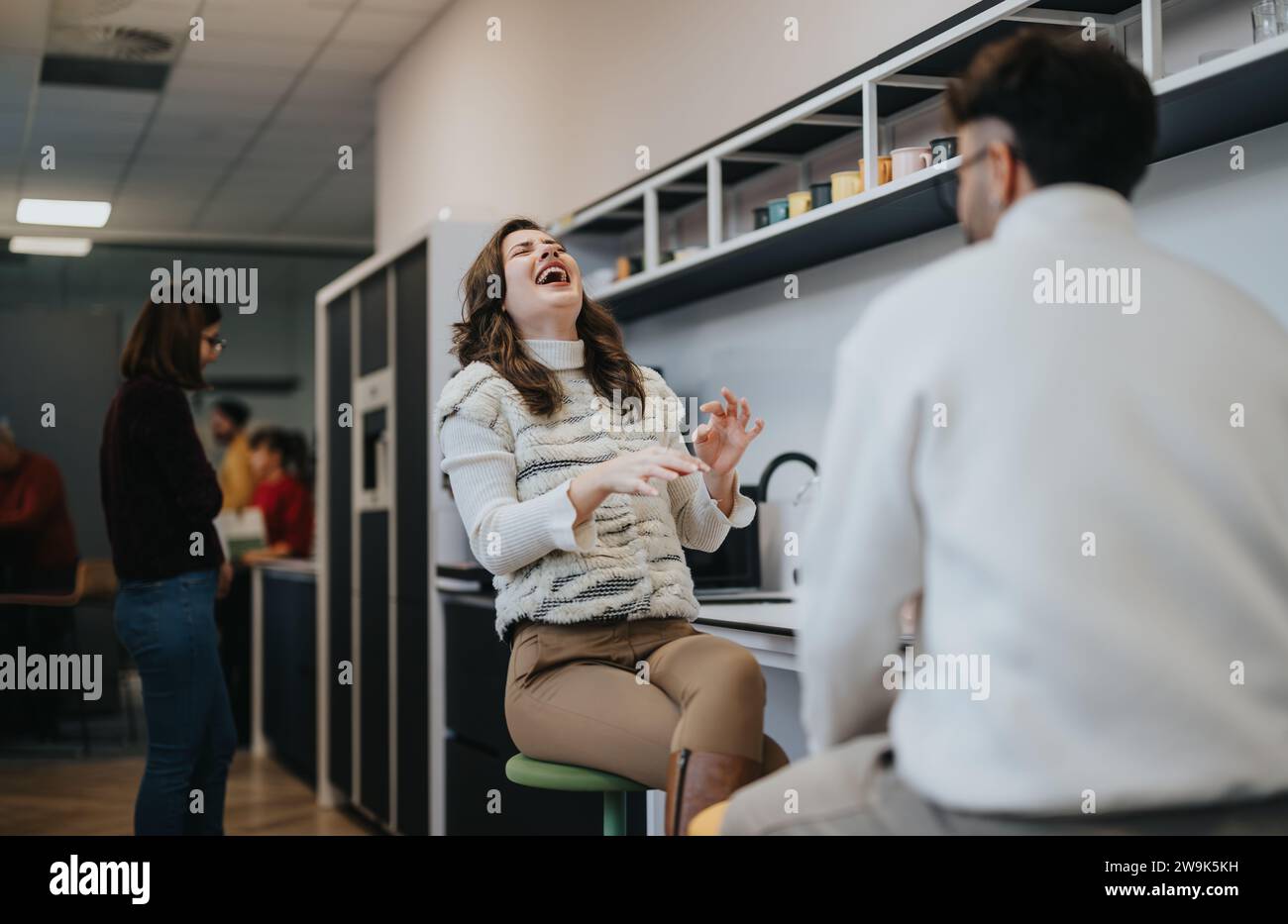 Female employee laughing while having fun conversation with her male ...