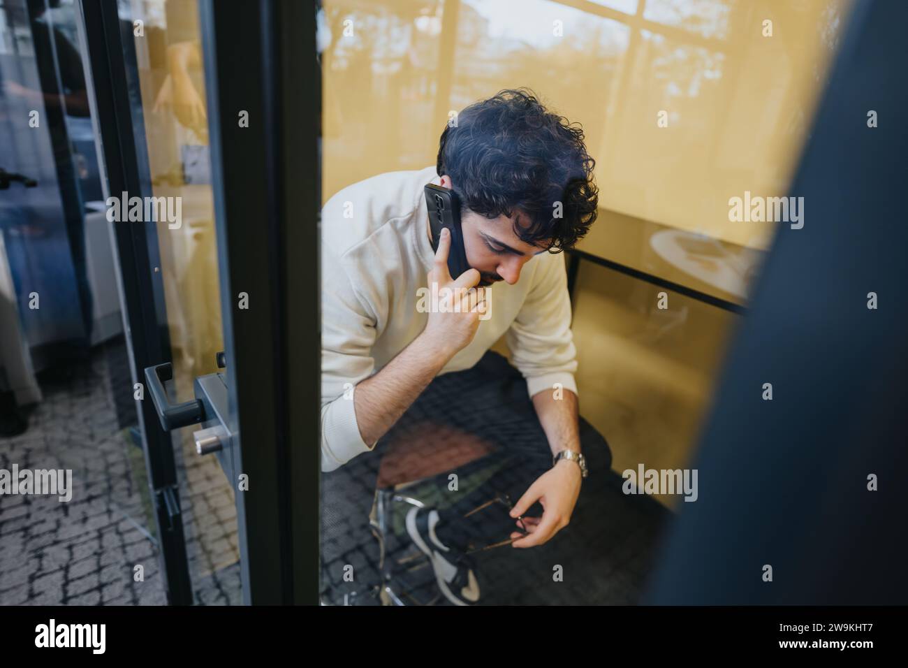 Male person having private phone call in soundproof phone booth at the ...