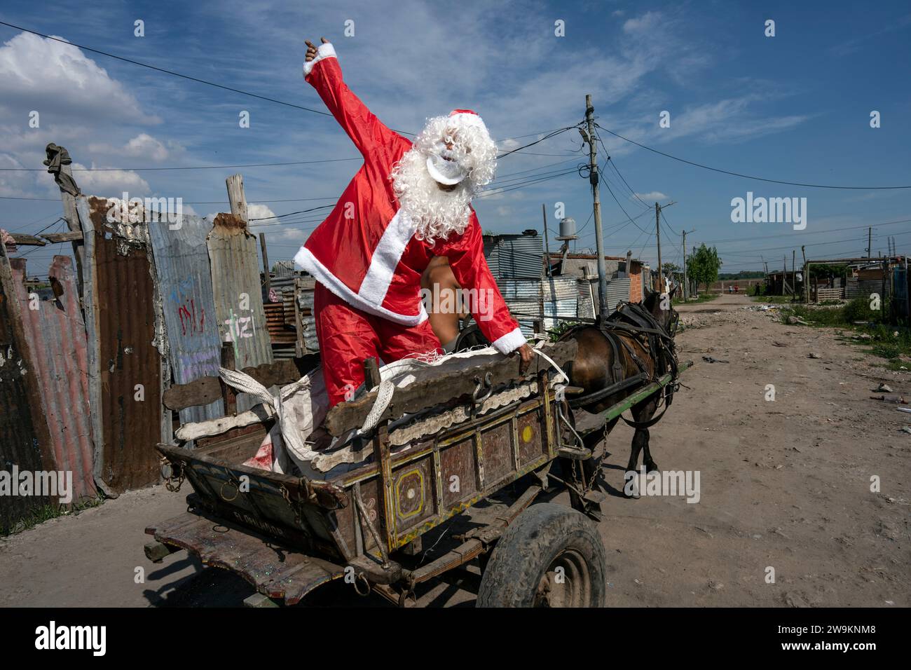 Tito Perez, dressed as Santa Claus, waves to children while standing on ...