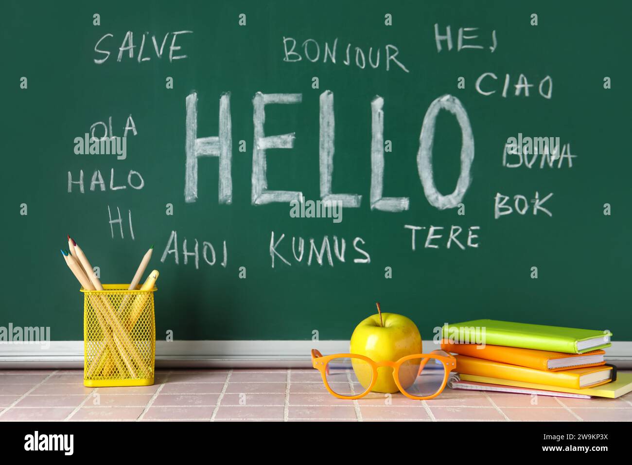 Blackboard with word HELLO in different languages and stationery on ...