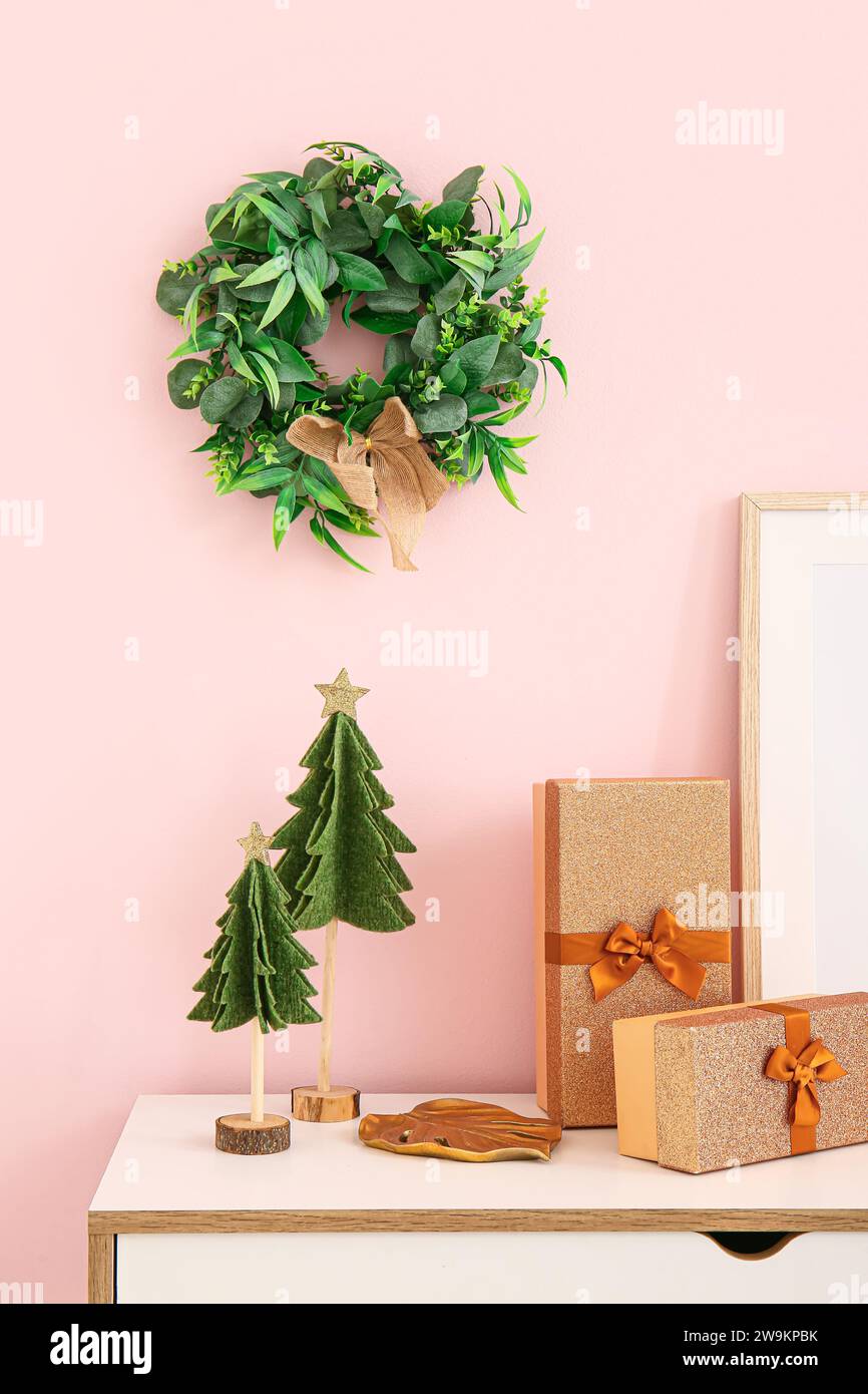 White chest of drawers with Christmas decorations and gift boxes near ...