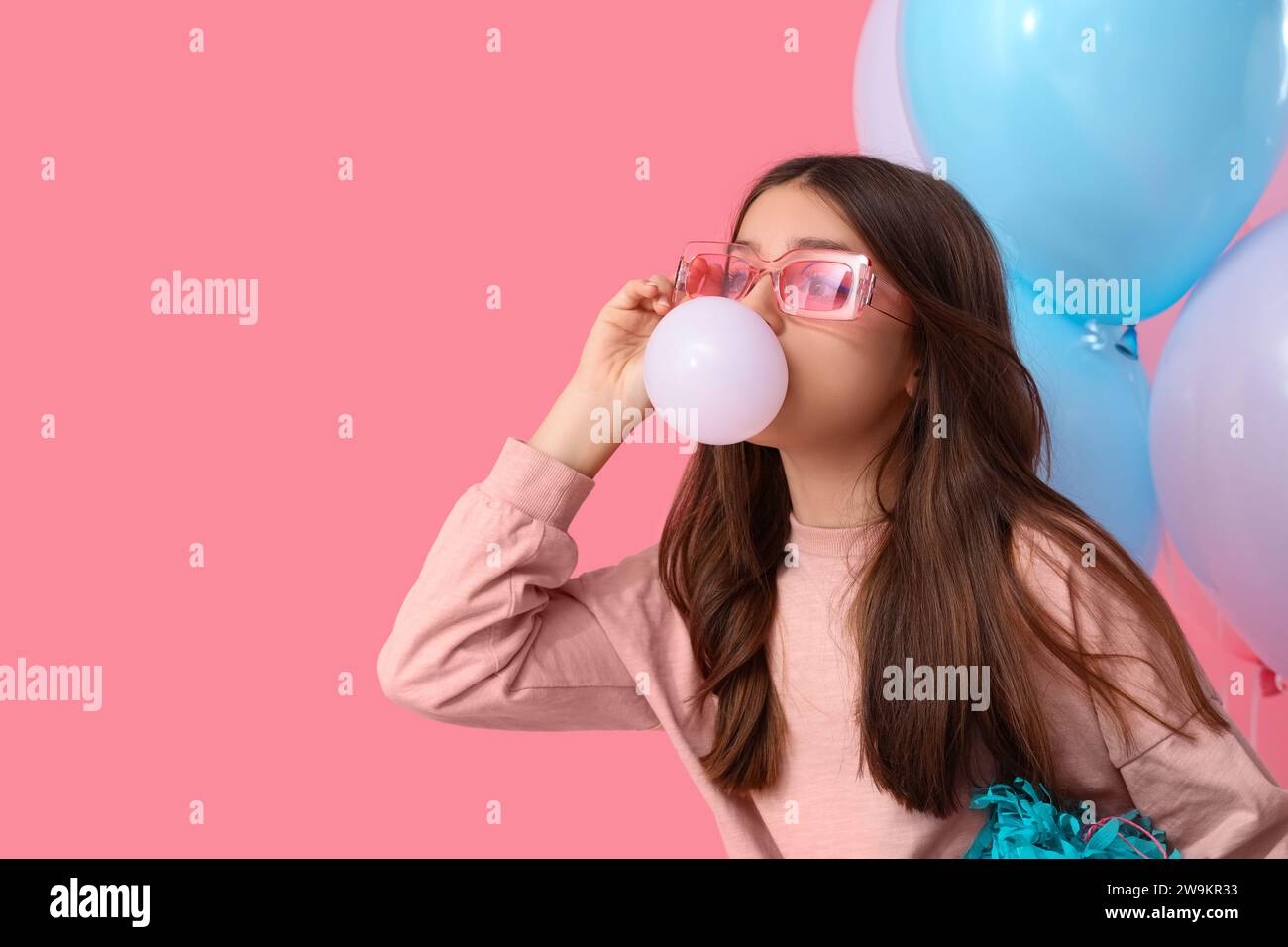 Trendy girl with balloons blowing bubble gum on pink background Stock ...