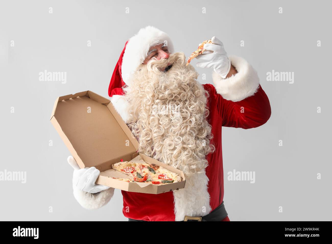 Santa Claus eating tasty pizza on white background Stock Photo - Alamy