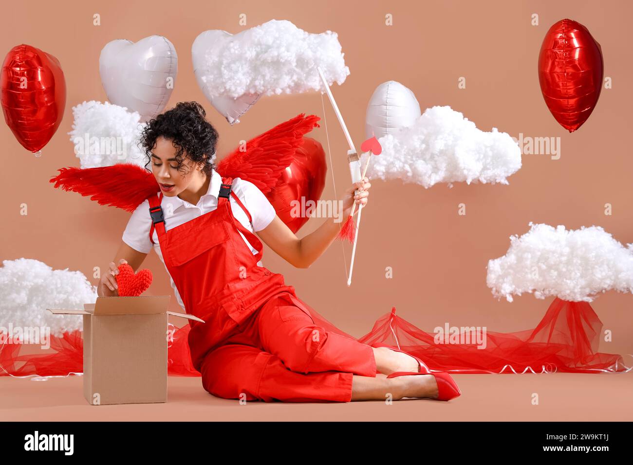 Young African-American woman dressed as Cupid with bow and heart from ...