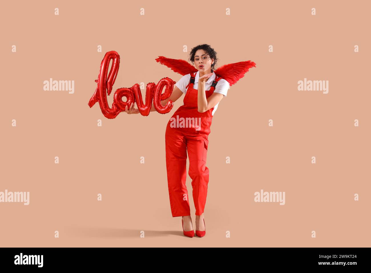 Young African-American woman dressed as Cupid with word LOVE made of ...