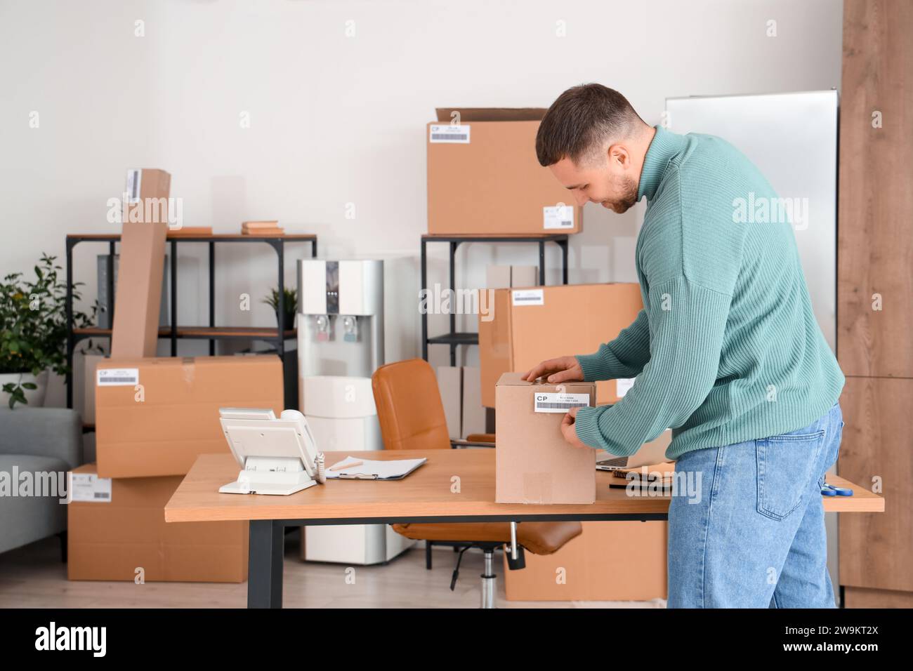 Male seller packing parcel for client in warehouse store Stock Photo ...