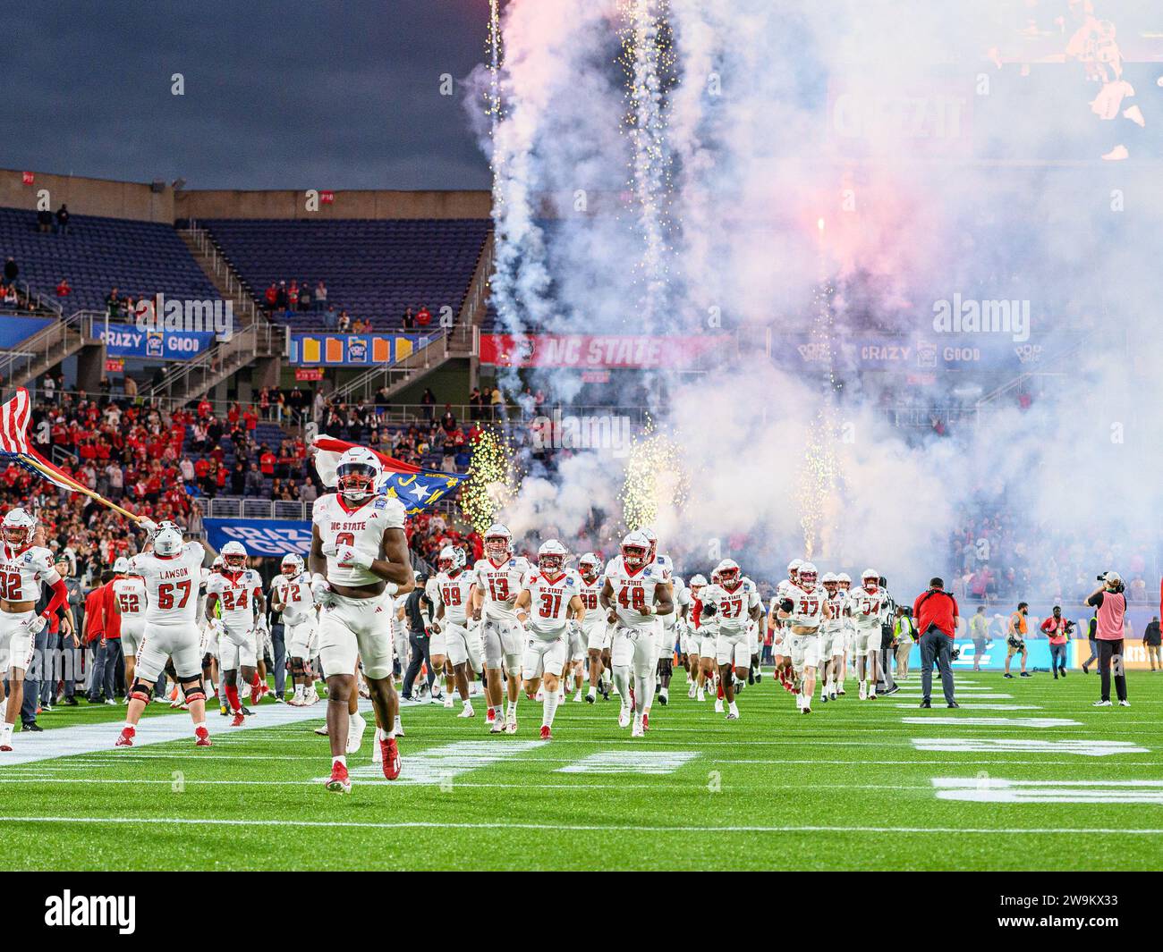 Orlando, FL, USA. 28th Dec, 2023. NC State players run onto the field ...