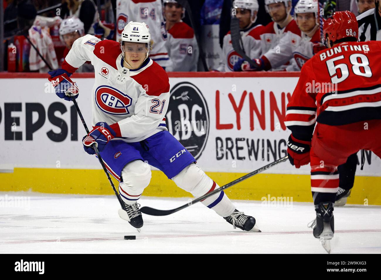 Montreal Canadiens' Kaiden Guhle (21) protects the puck from Carolina ...