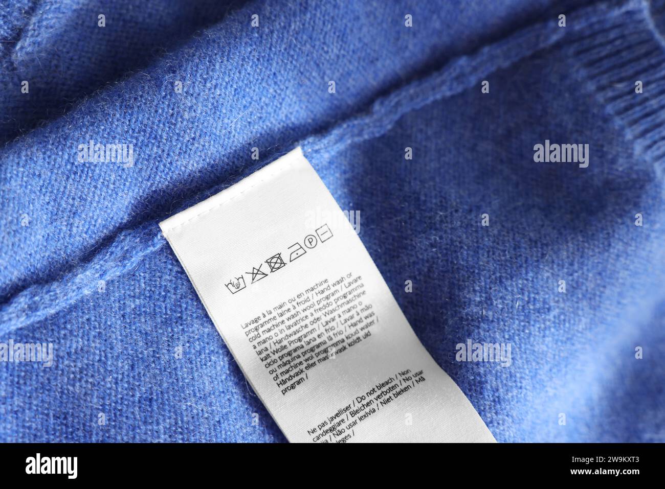 Clothing label in different languages on blue garment, closeup Stock ...