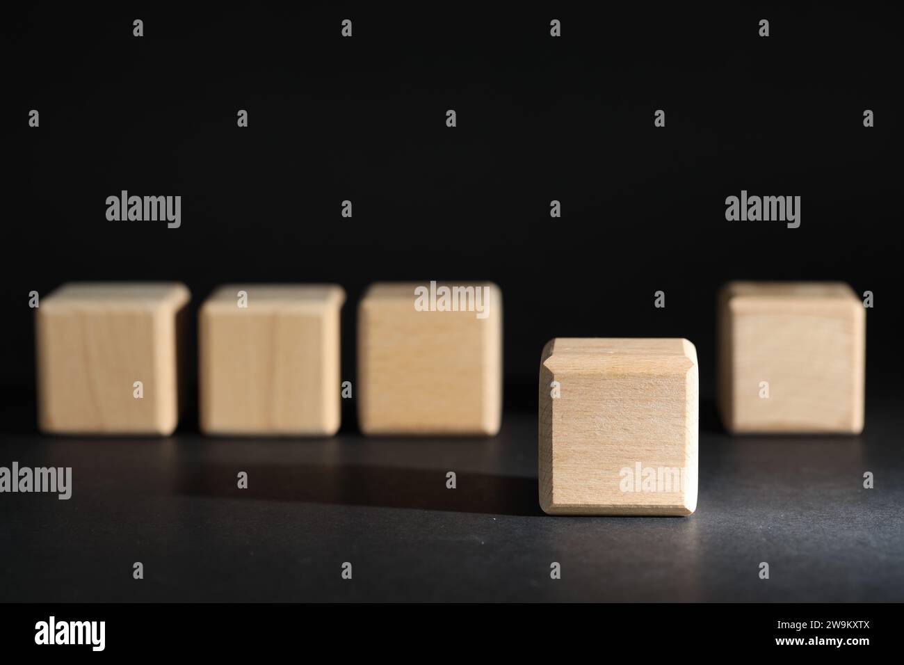 Empty wooden cubes on grey table against black background Stock Photo ...