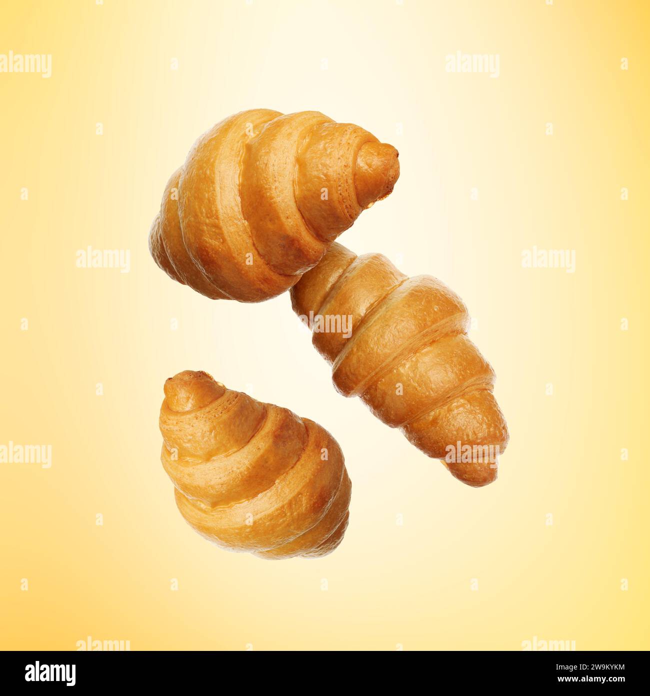 Golden croissants falling on golden gradient background Stock Photo - Alamy