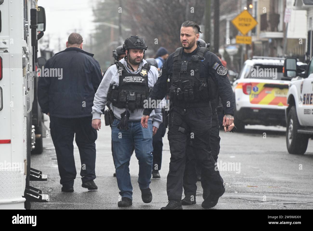 SWAT officers rush out of the residence with a person transporting them ...