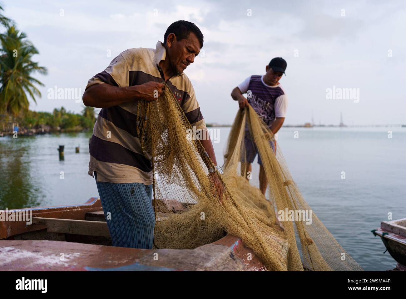 Fishermen are seen preparing their nets before going out on a fishing ...