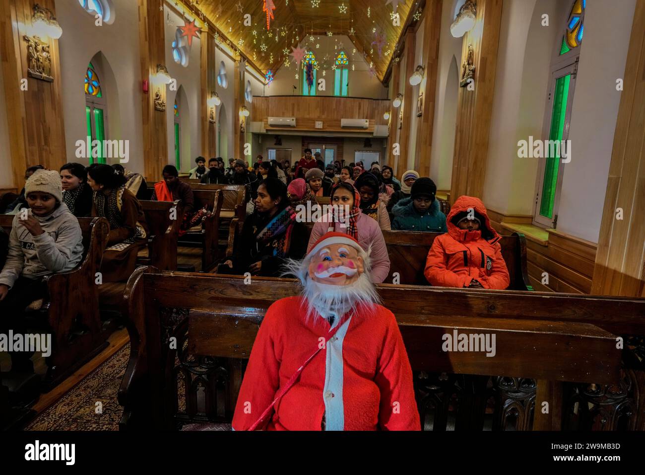 A boy dressed as Santa Claus attends Christmas prayers at the Holy ...